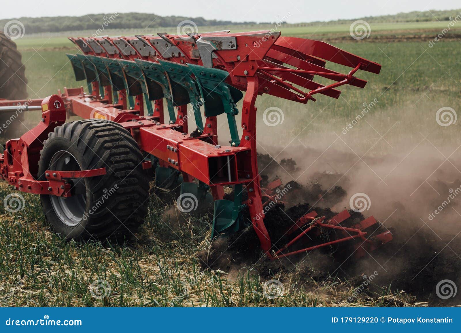 The Process of Plowing the Soil with a Red Plow while Moving Stock ...