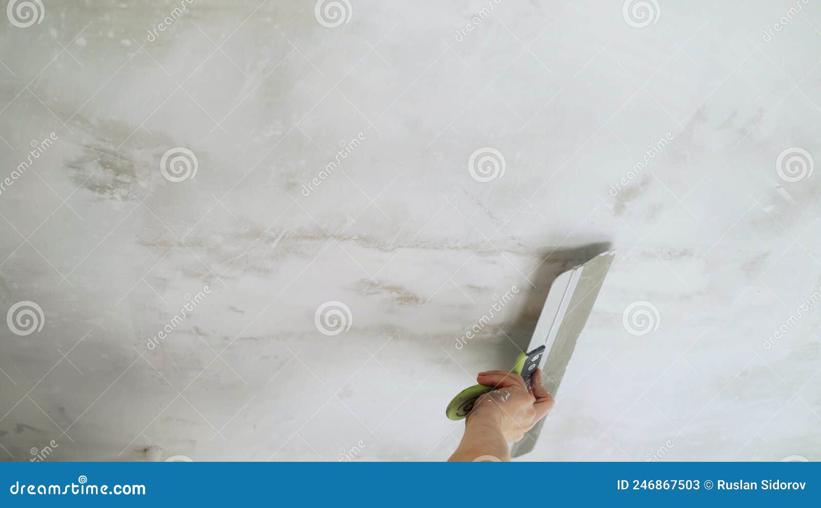 Man with a Spatula and Putty, Applies Mastic To the Ceiling To Level ...