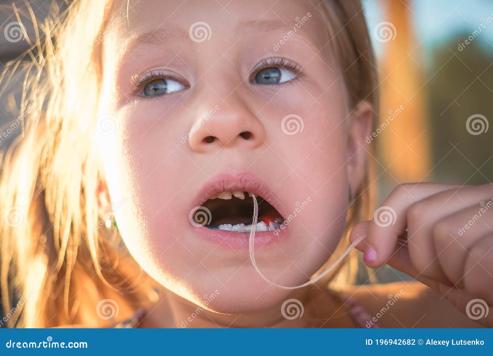The Process of Removing a Baby Tooth Using a Thread Stock Photo - Image ...