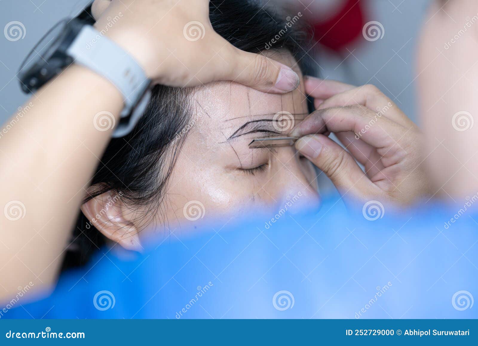 The Process of Shaping Eyebrows by a Beauty Master with a Thread for a Young Asian Lady ...