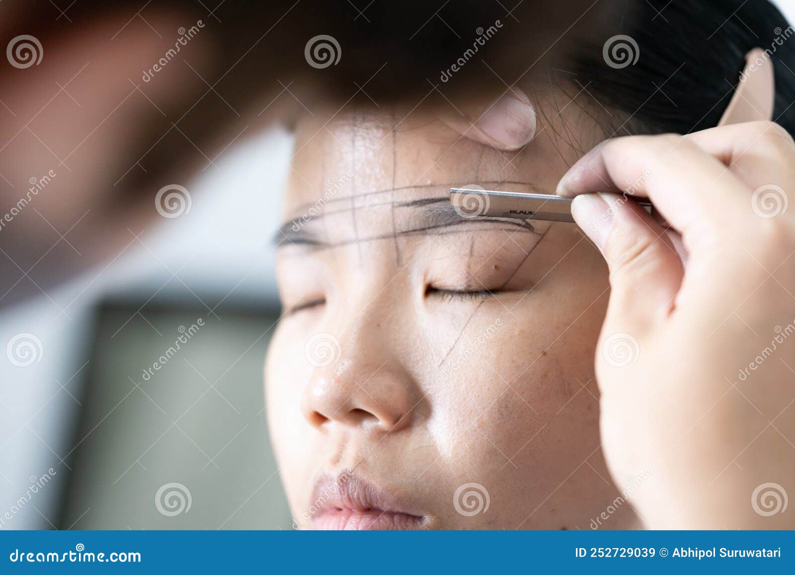 The Process of Shaping Eyebrows by a Beauty Master with a Thread for a Young Asian Lady ...