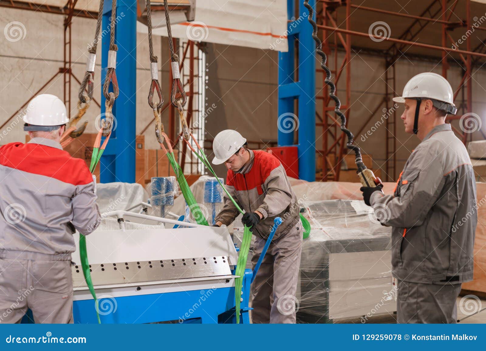Workers Adjusts The Machine In The Warehouse. The Production Of ...