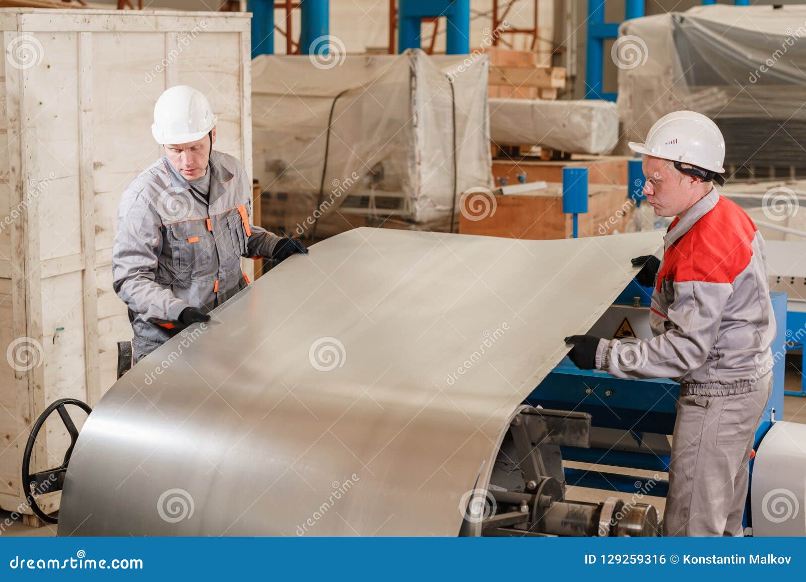 Workers Adjusts The Machine In The Warehouse. The Production Of ...