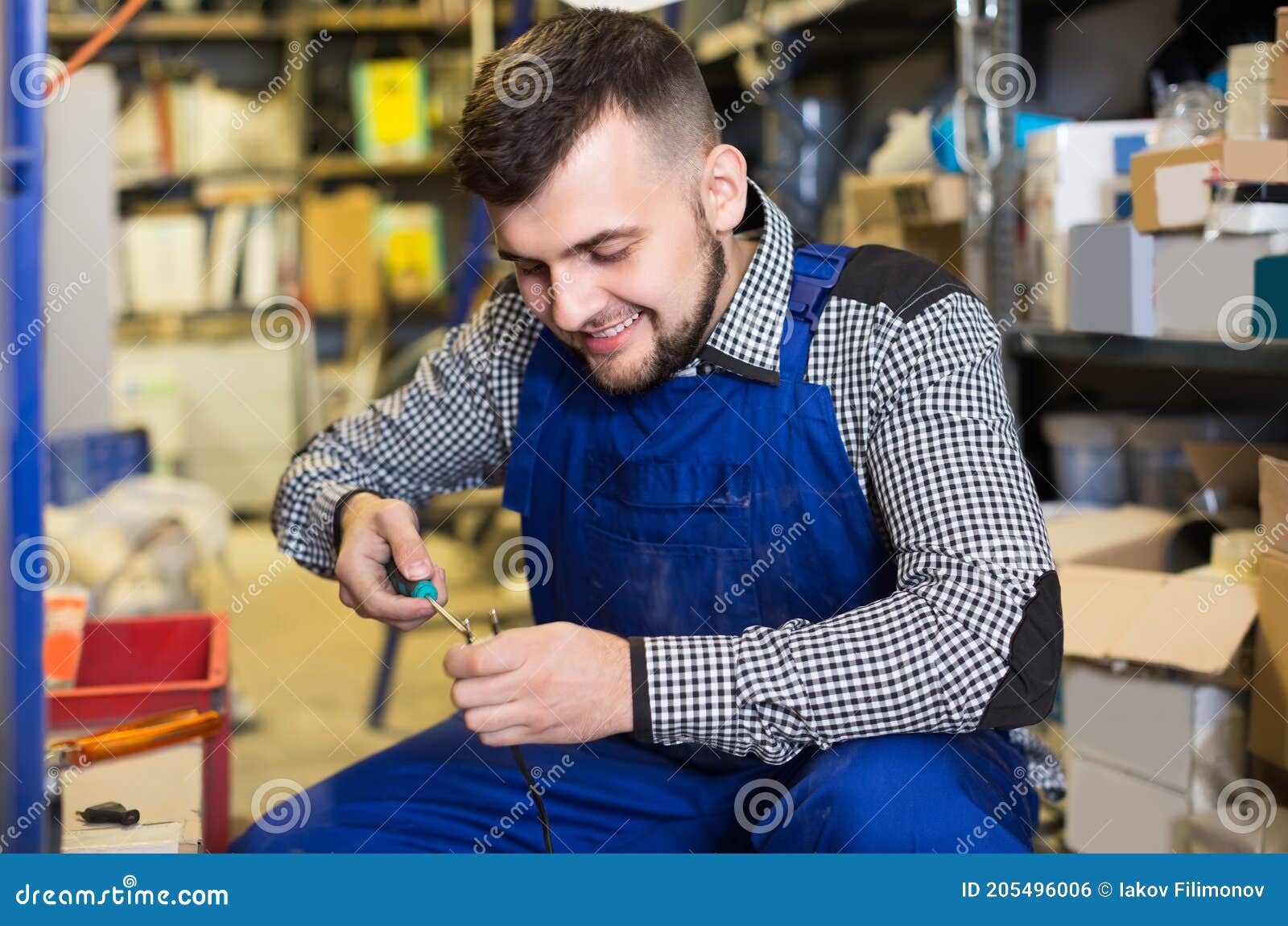 Production Worker in Uniform Working with Tools for Fixing Adaptor Plug ...
