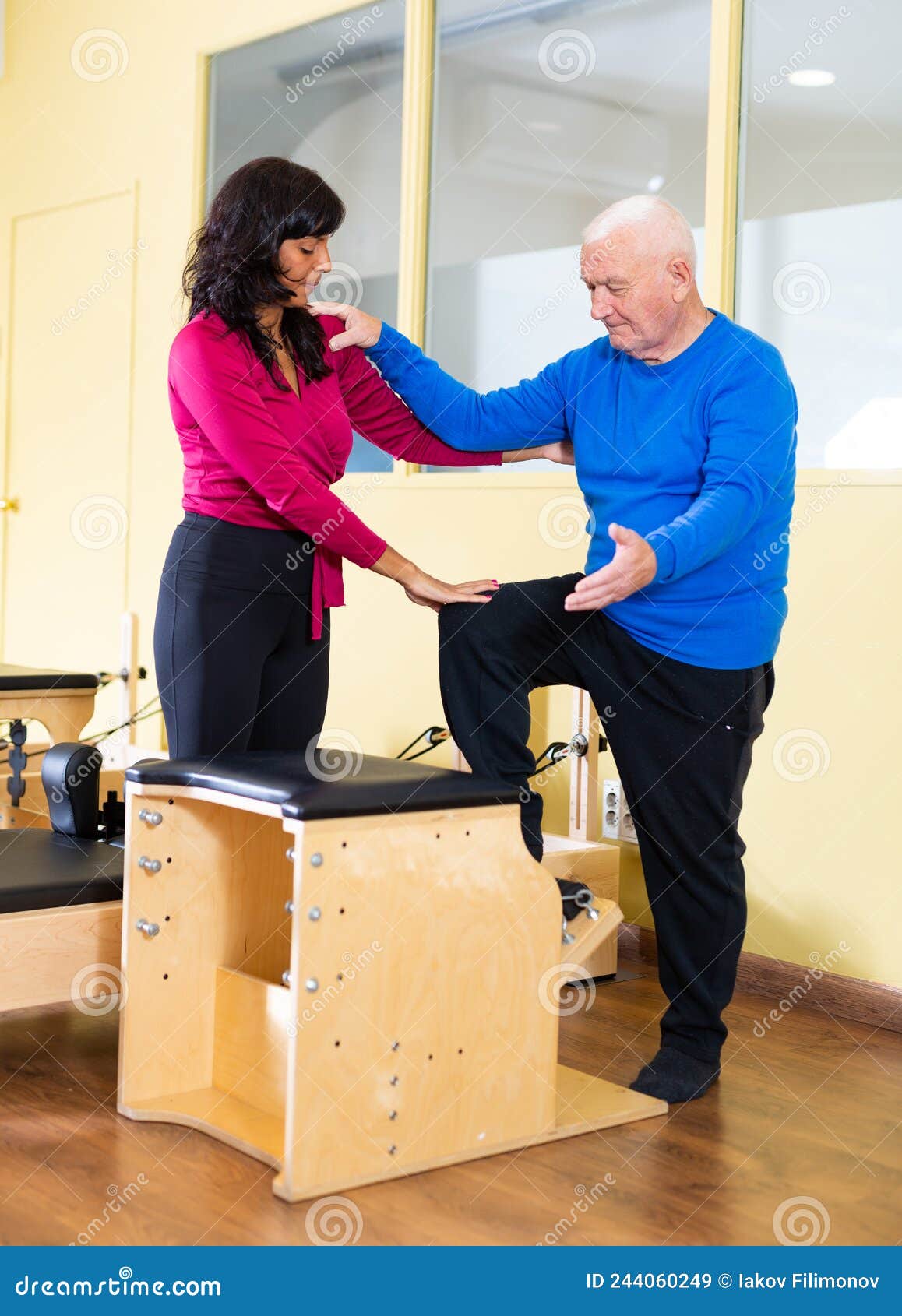 Profesora De Pilates Hispana Ayuda a Un Hombre Mayor a Hacer Ejercicio ... Profesora De Pilates Hispana Ayuda a Un Hombre Mayor a Hacer Ejercicio ...