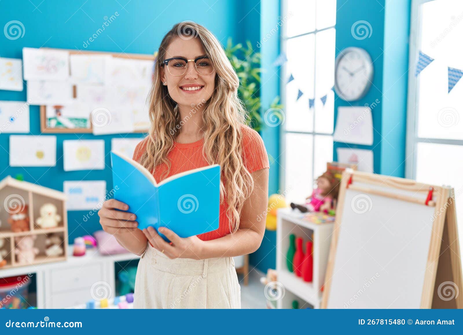 Profesora Rubia Joven Leyendo Libro De Pie En Kindergarten Foto de ...