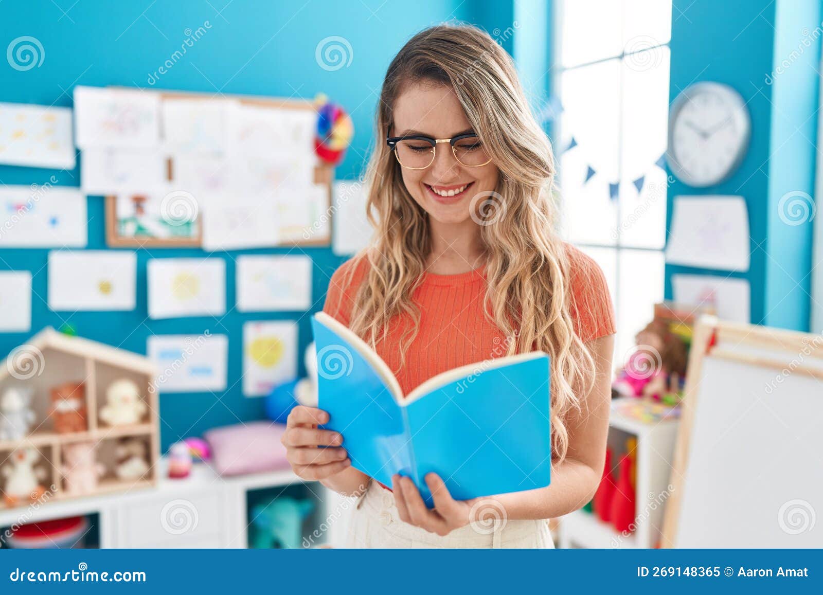Profesora Rubia Joven Leyendo Libro De Pie En Kindergarten Imagen de ...