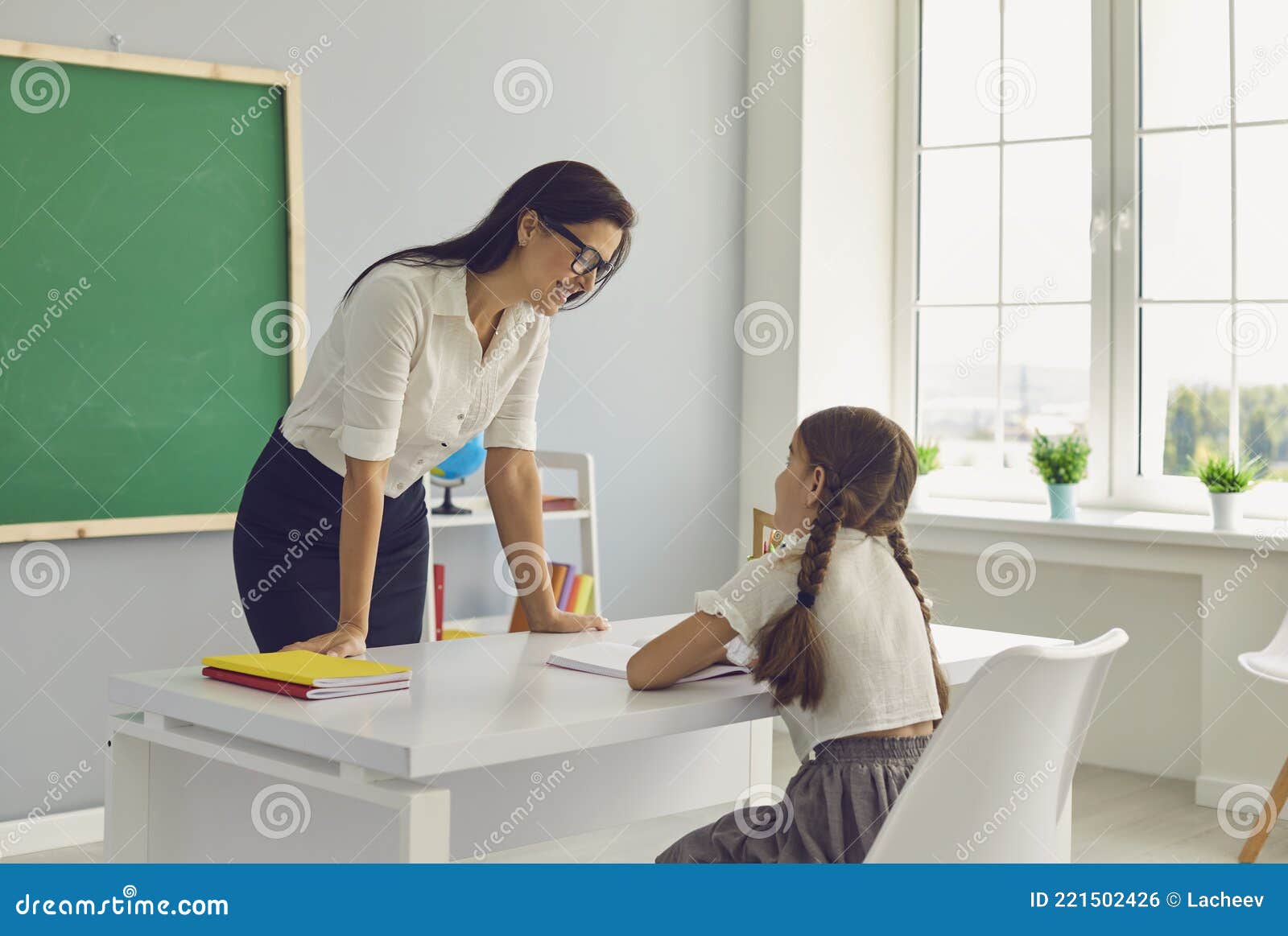 Profesora Y Alumna De Primaria De Sexo Femenino Que Habla En El Aula Foto De Archivo Imagen De