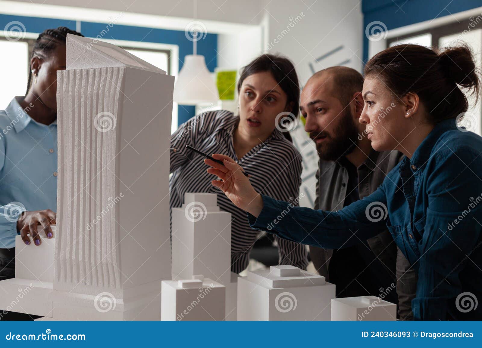 Professional Architect with Working Partners Pointing at Skyscraper ...