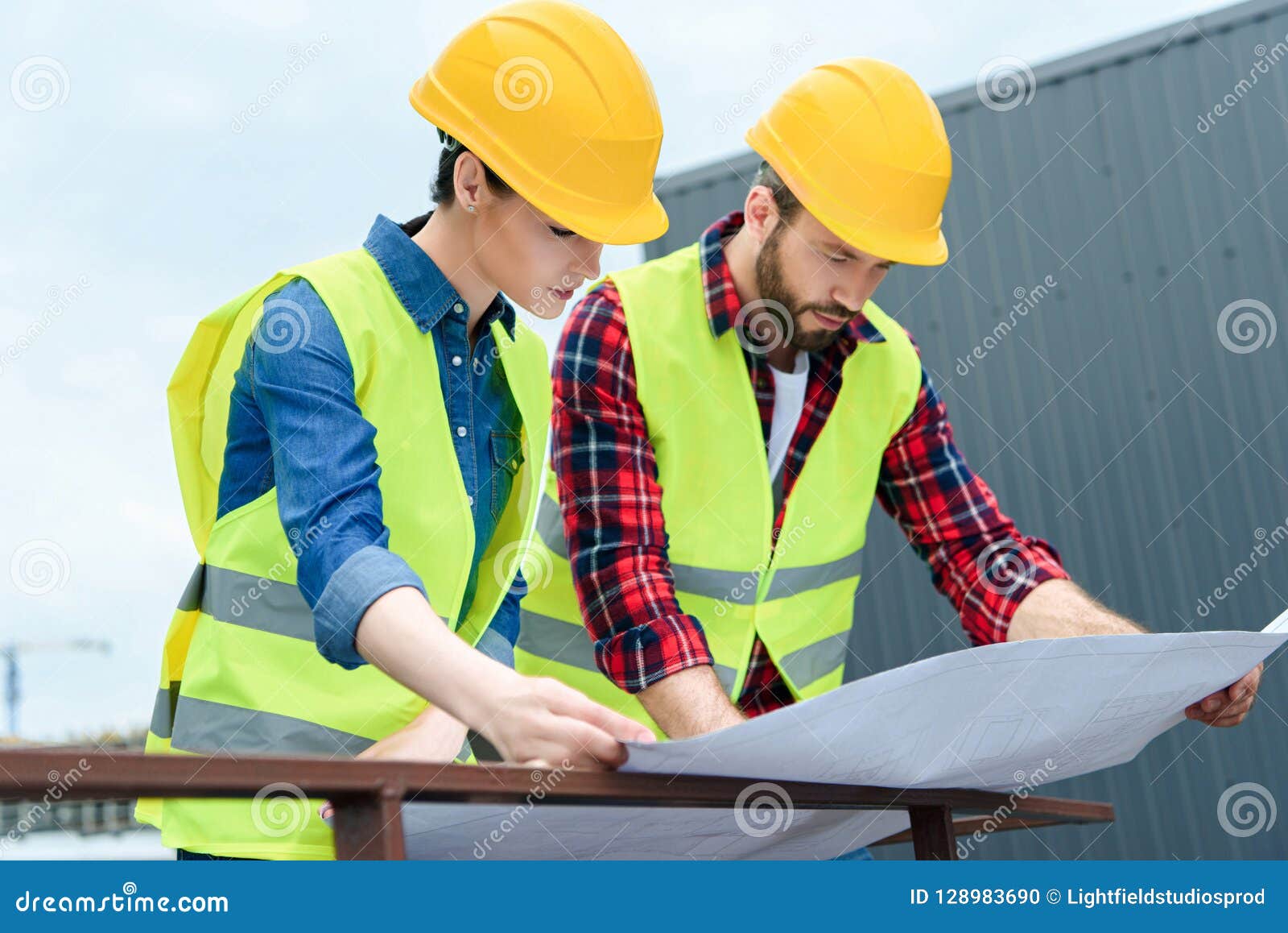 Professional Architects in Safety Vests and Helmets Working with ...