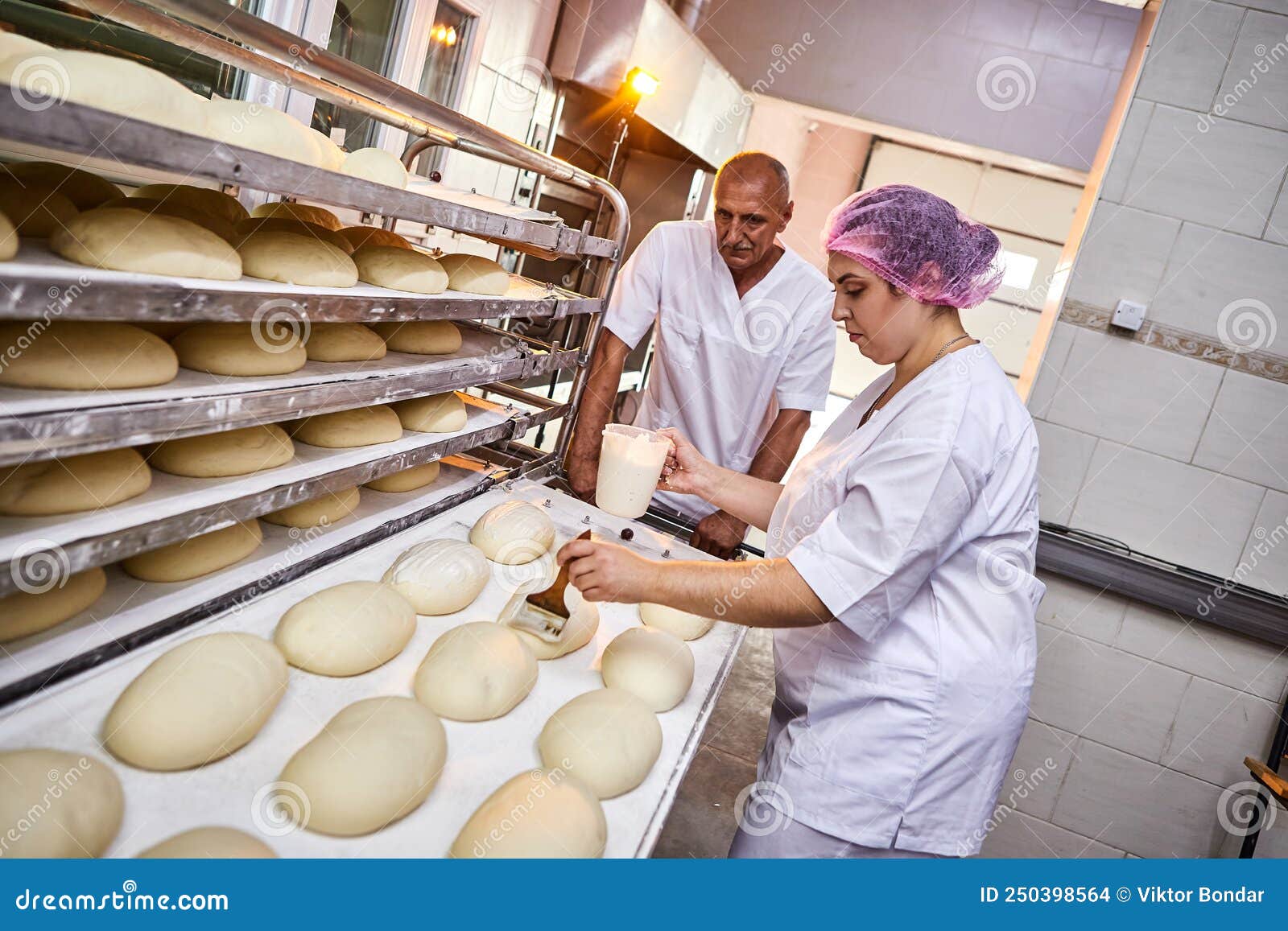 Professional Baker in Uniform Smears Butter Bread Dough for Baking at ...