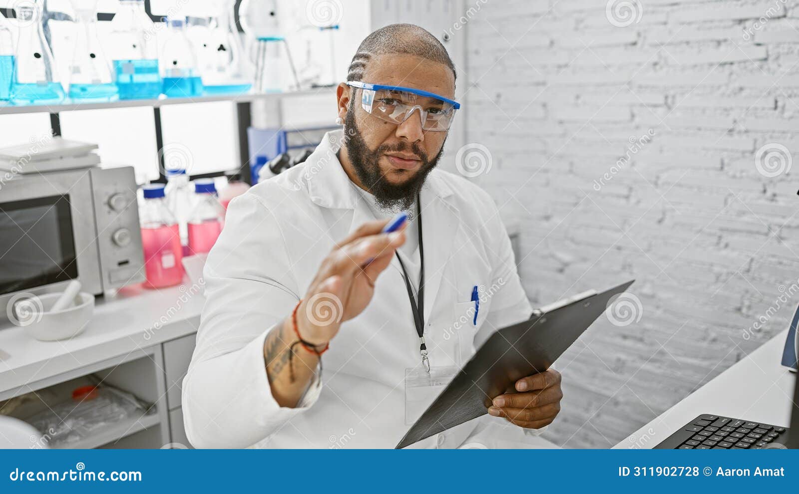 Professional Black Man in Lab Coat Holding a Clipboard in a Modern ...