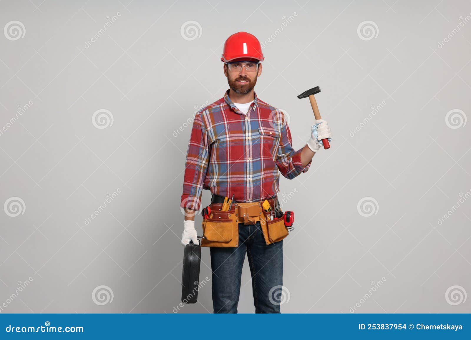 Professional Builder in Hard Hat with Hammer and Tool Belt on Light ...