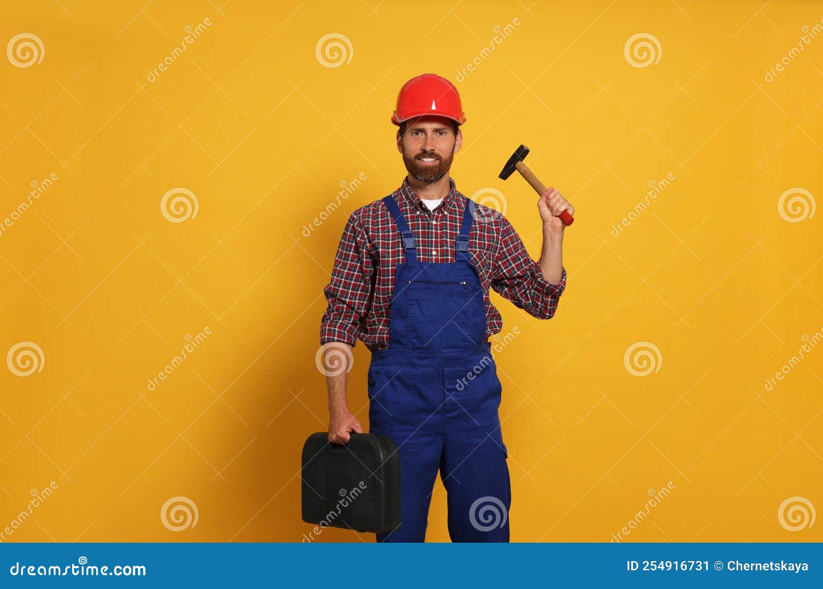 Professional Builder in Uniform with Hammer and Toolbox on Yellow ...