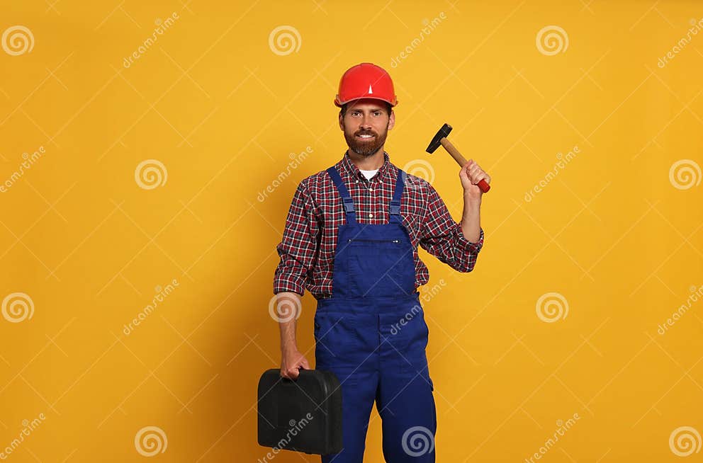 Professional Builder in Uniform with Hammer and Toolbox on Yellow ...