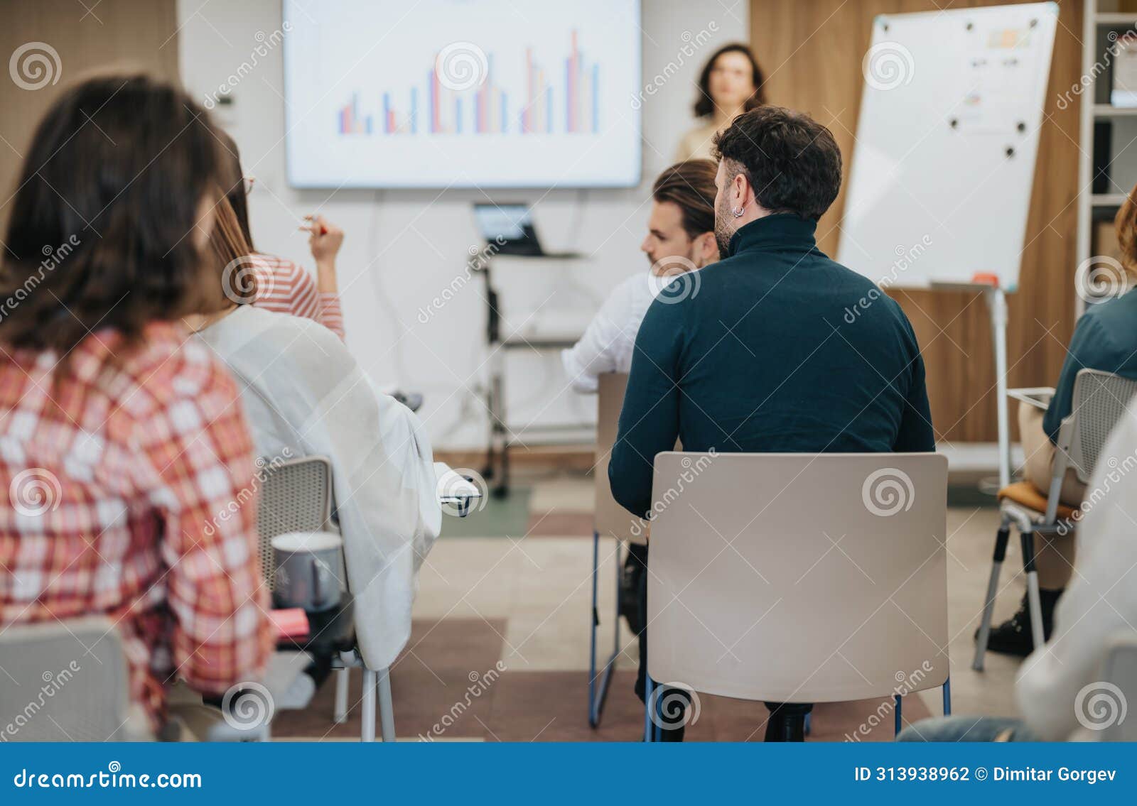 Focused Professionals Watching a Presenter Explaining a Bar Chart in a ...