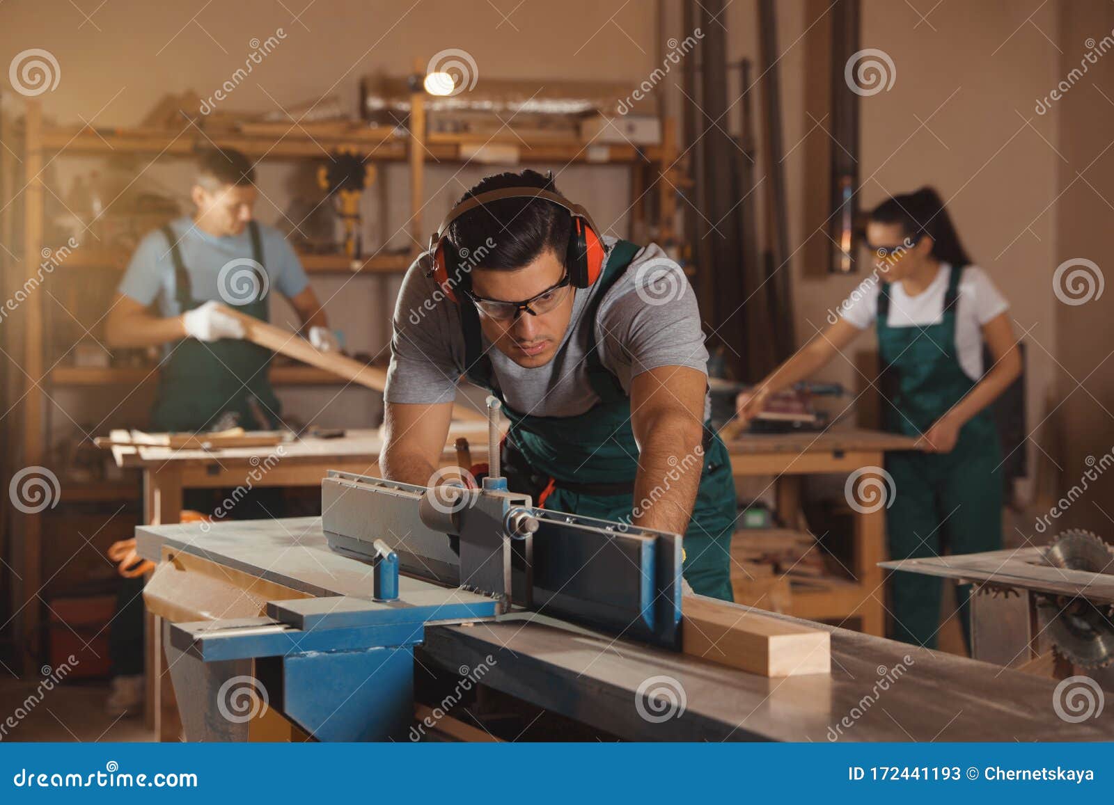 Professional Carpenter Working with Surface Planer and Colleagues Stock ...