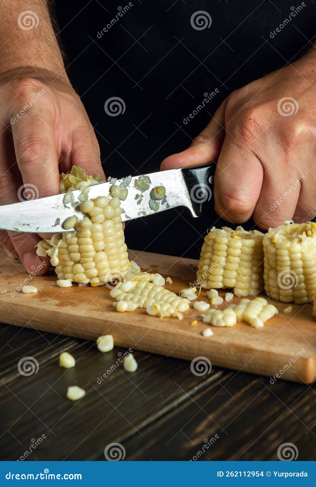 Professional Chef Cuts the Boiled Maize with a Knife. Corn is an ...