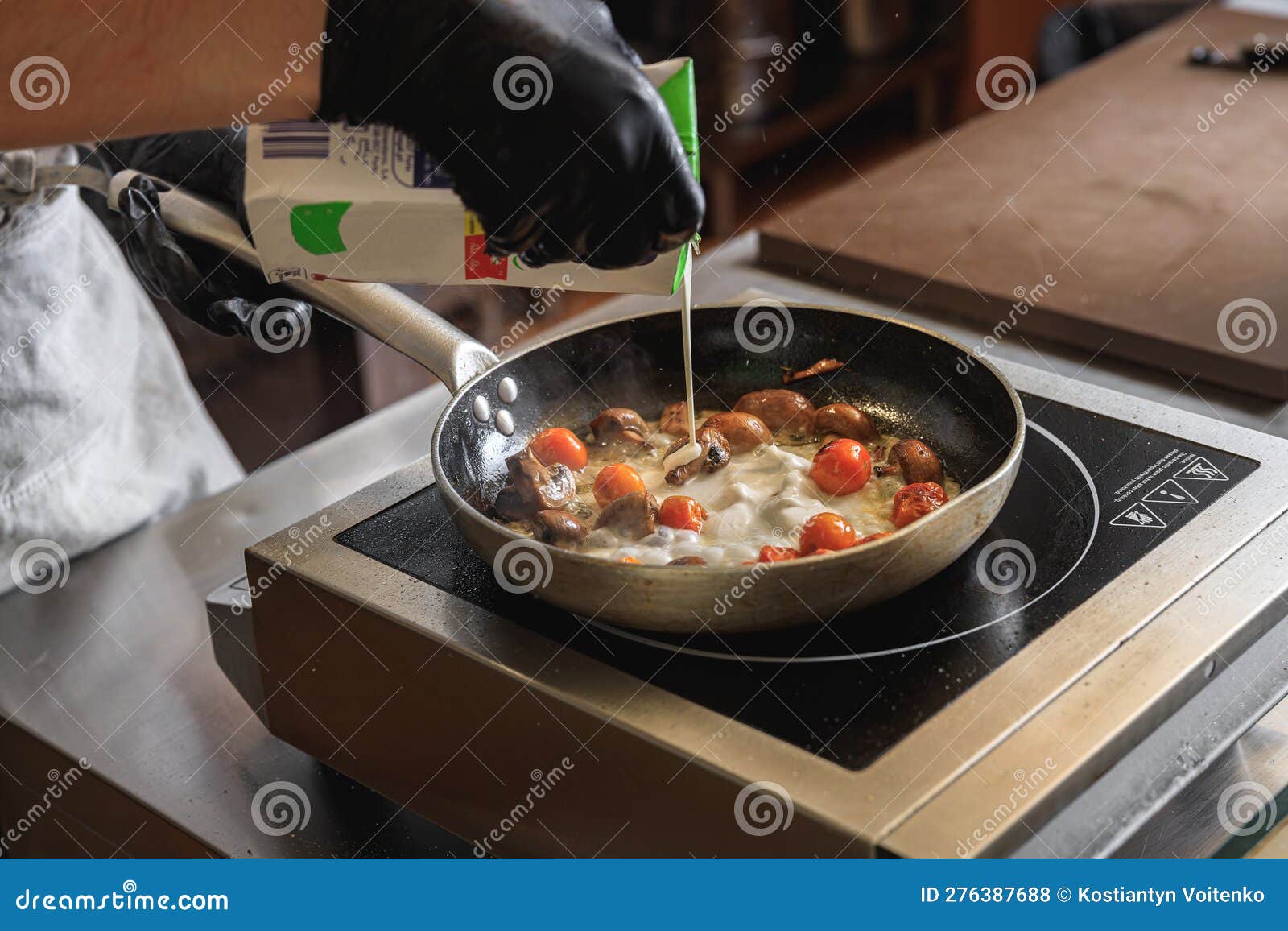 The Professional Chef in Uniform Adding Cream into Frying Pan with Dish ...