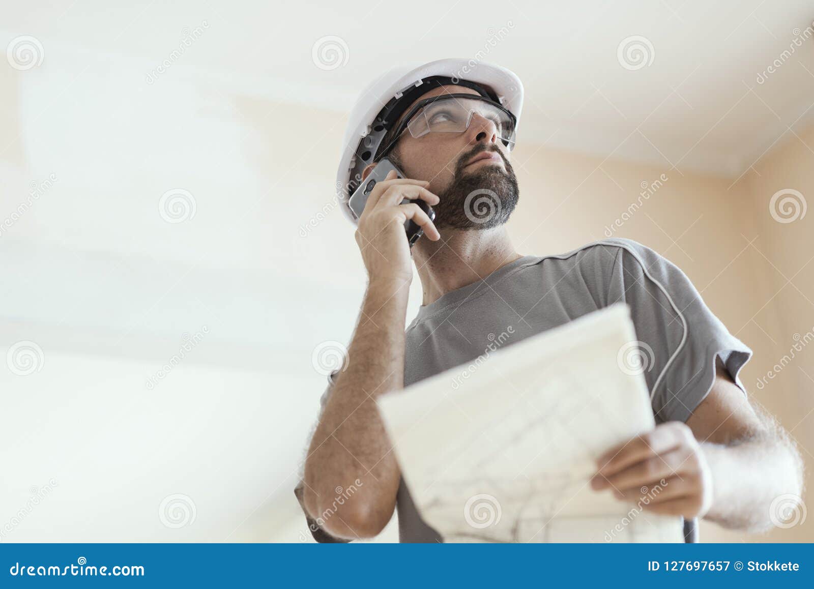 Professional Construction Worker Checking a Project and Calling Stock ...