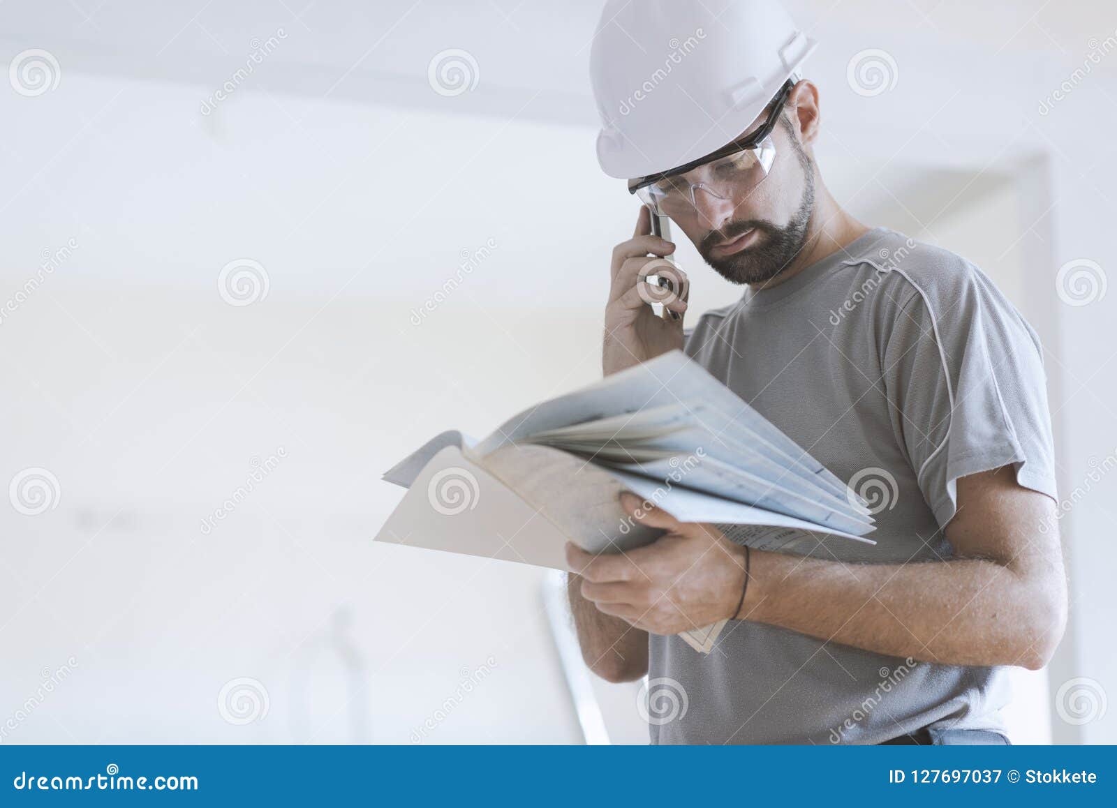 Professional Construction Worker Checking a Project and Calling Stock ...