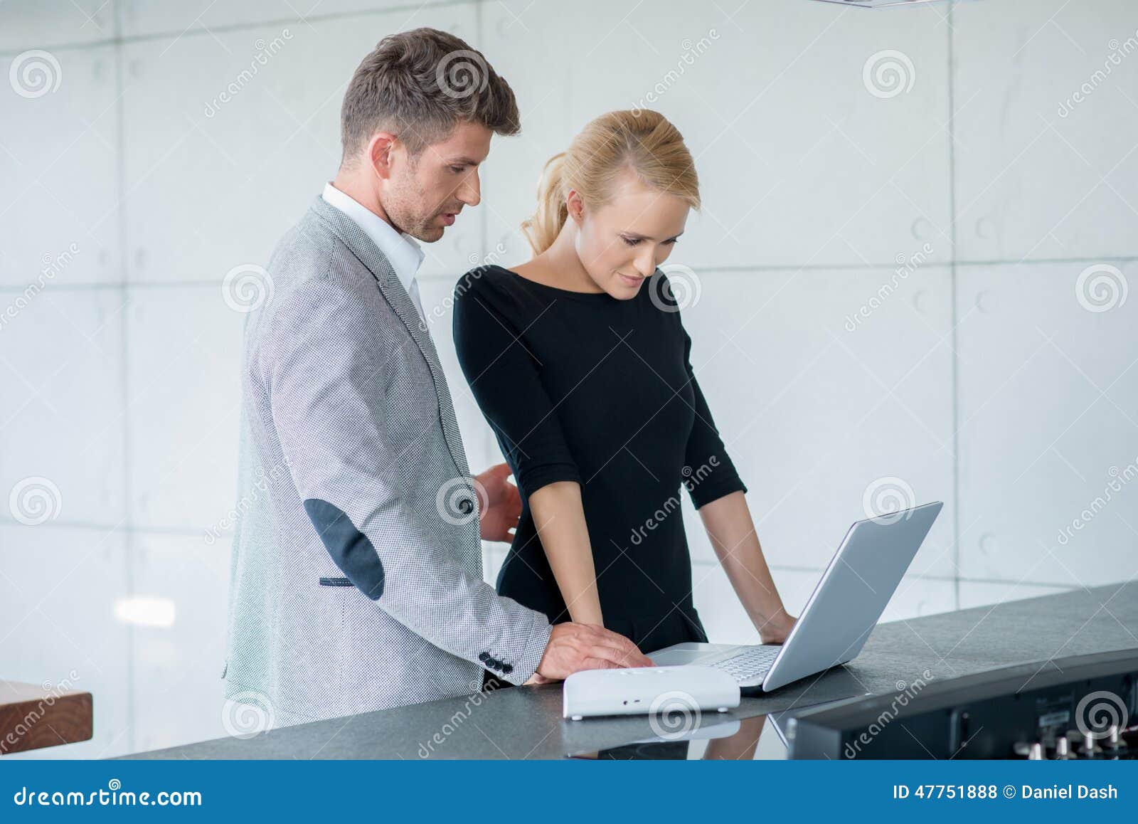 Professional Couple Looking Down at Laptop Stock Photo - Image of ...