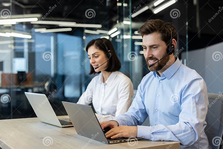Professional Customer Service Representatives Using Headsets and Laptops in Modern Office ...