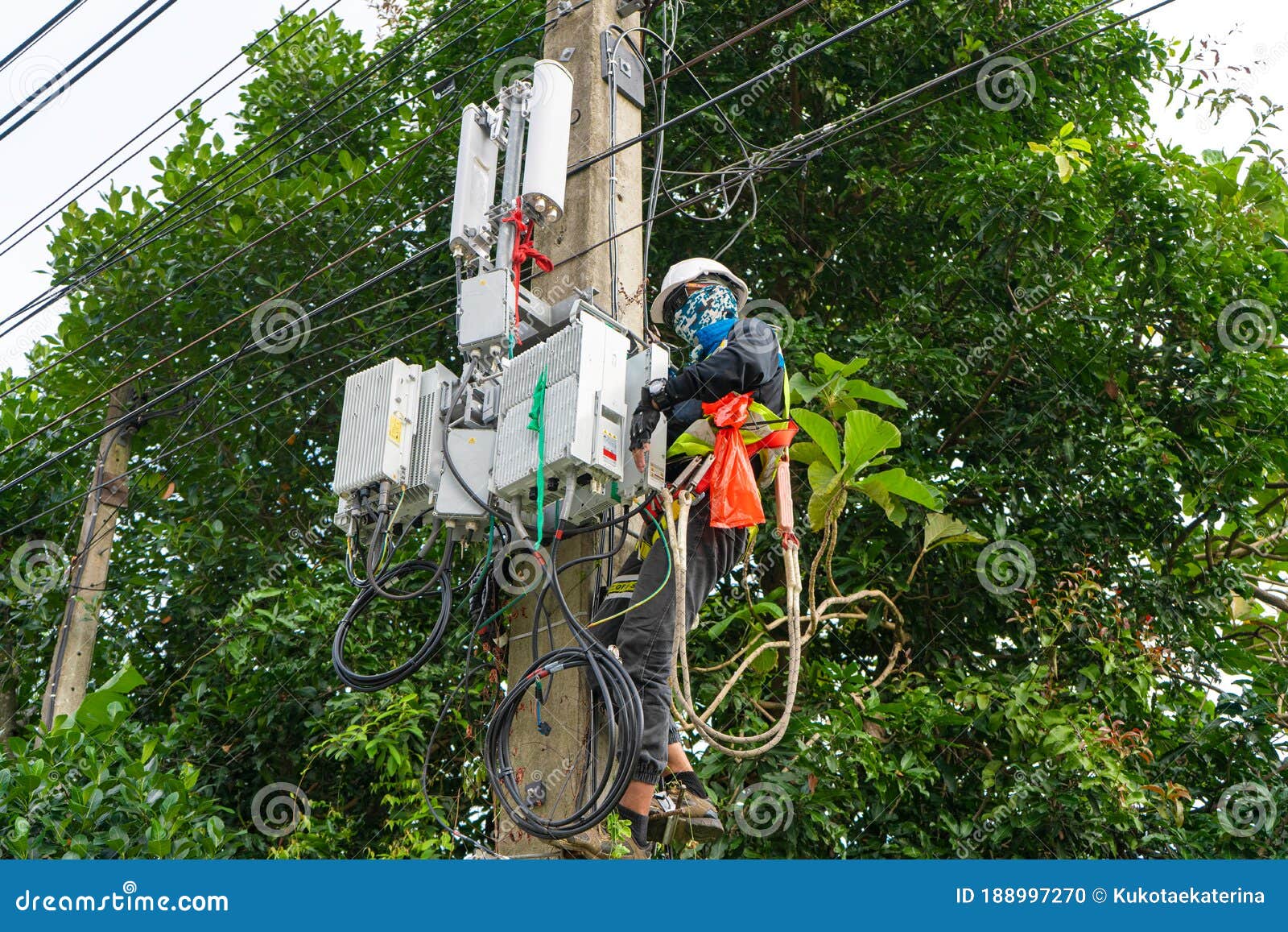 A Professional Electrician Performs Installation Work on a Pole. an ...