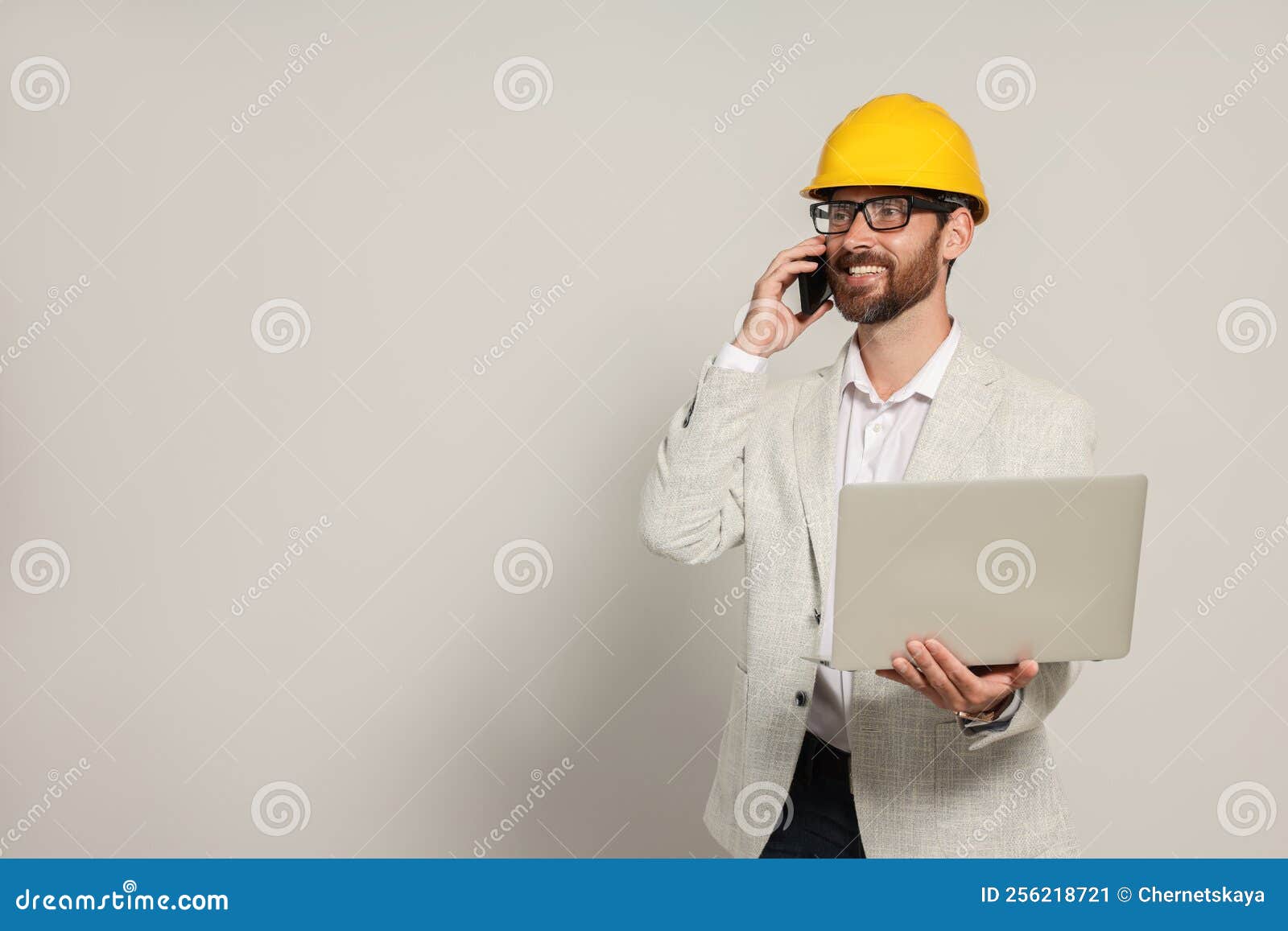 Professional Engineer in Hard Hat with Laptop Talking on Phone Against ...