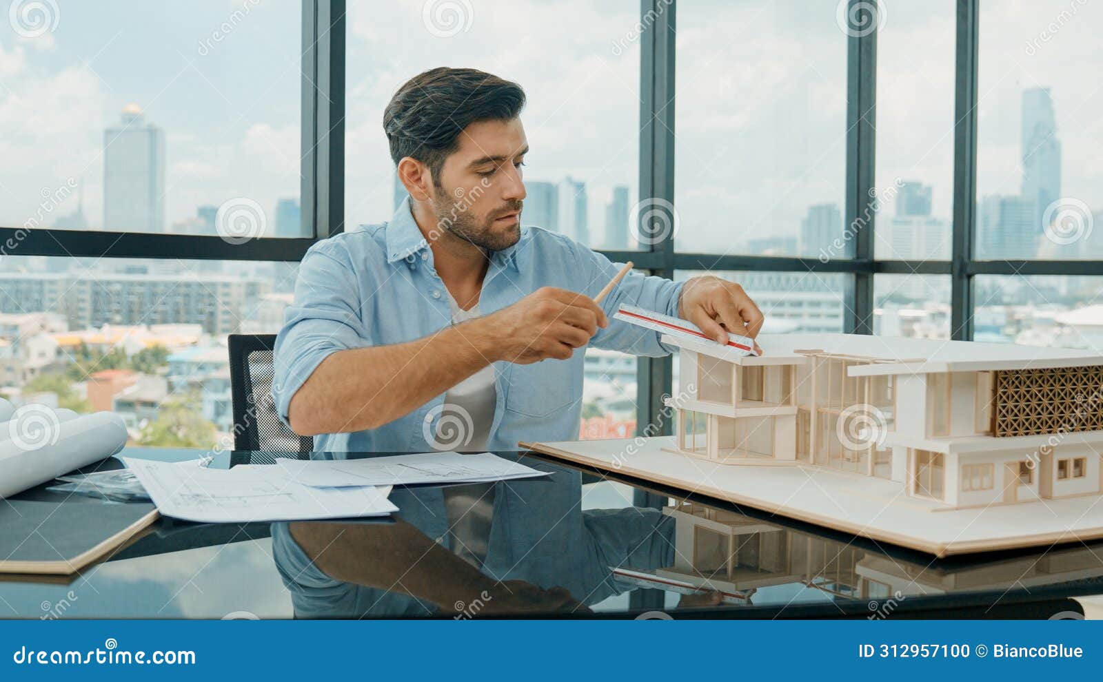 Skilled Engineer Looking at Blueprint while Measure House Model ...