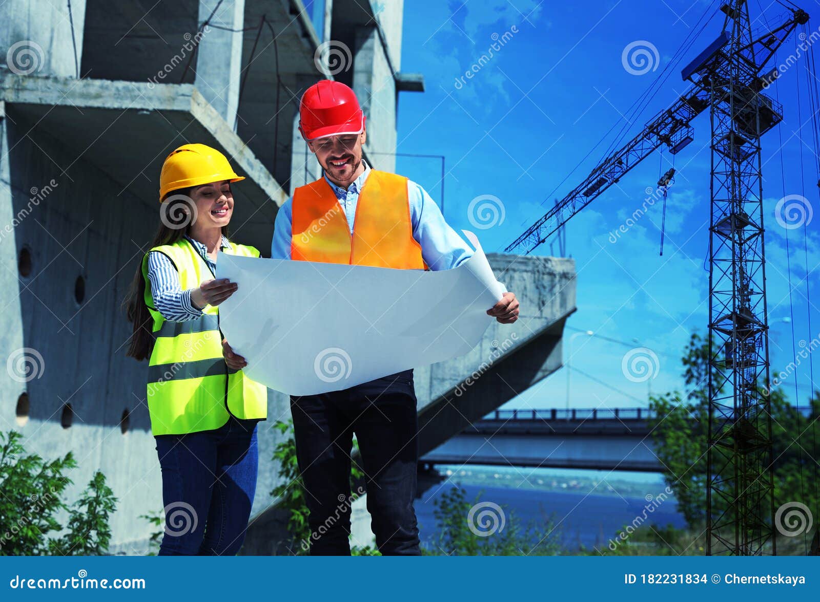 Engineers in Safety Equipment with Drafting at Construction Site Stock ...