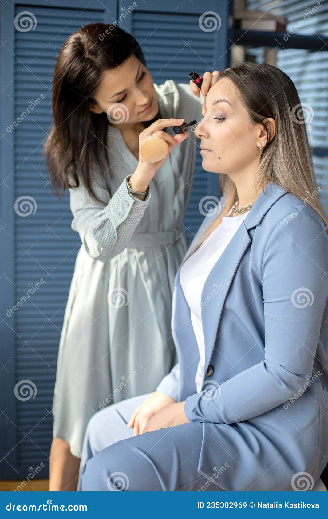 Professional Female Makeup Artist Applying Cosmetics On Model Face Use