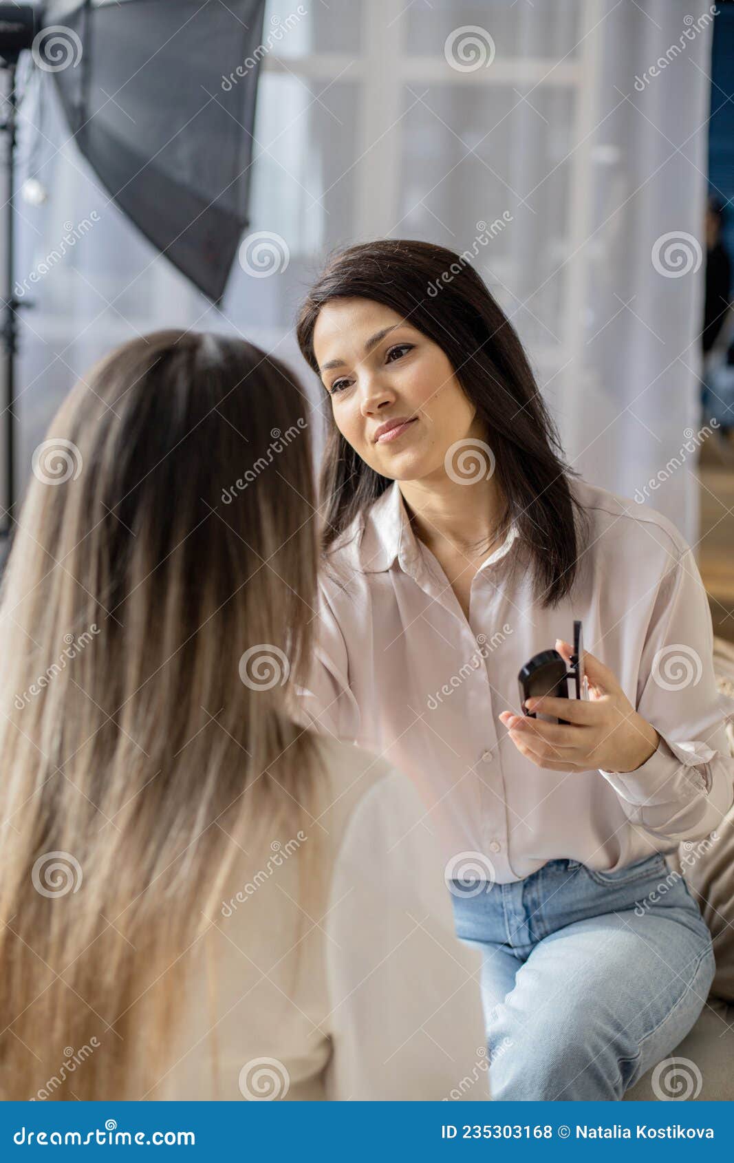 Professional Female Makeup Artist Applying Cosmetics On Model Face Use