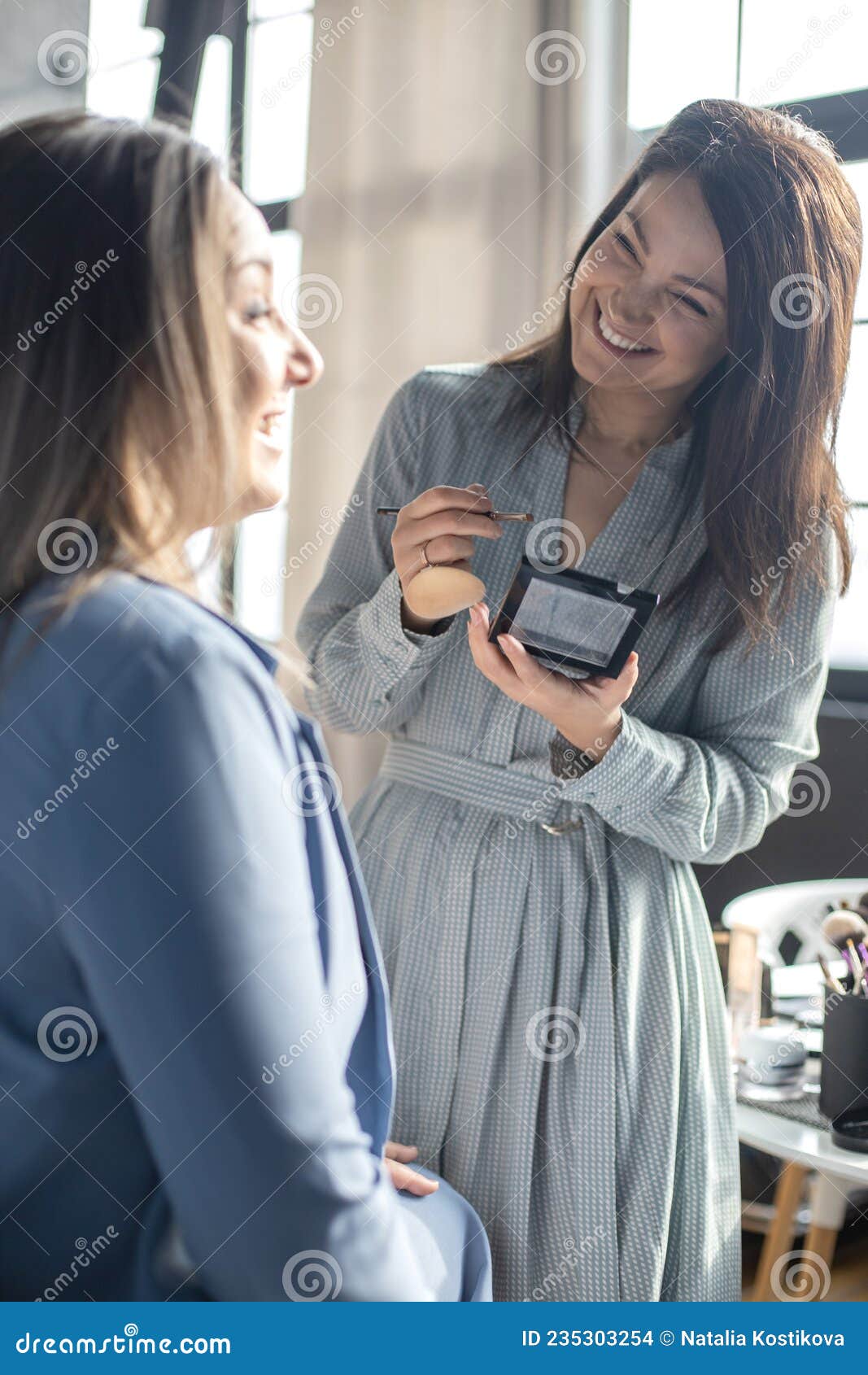 Professional Female Makeup Artist Applying Cosmetics On Model Face Use