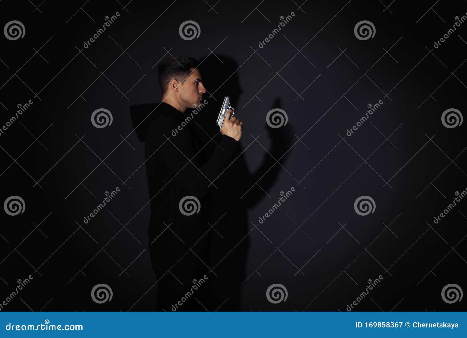 Professional Killer with Gun on Black Background. Space for Text Stock ...