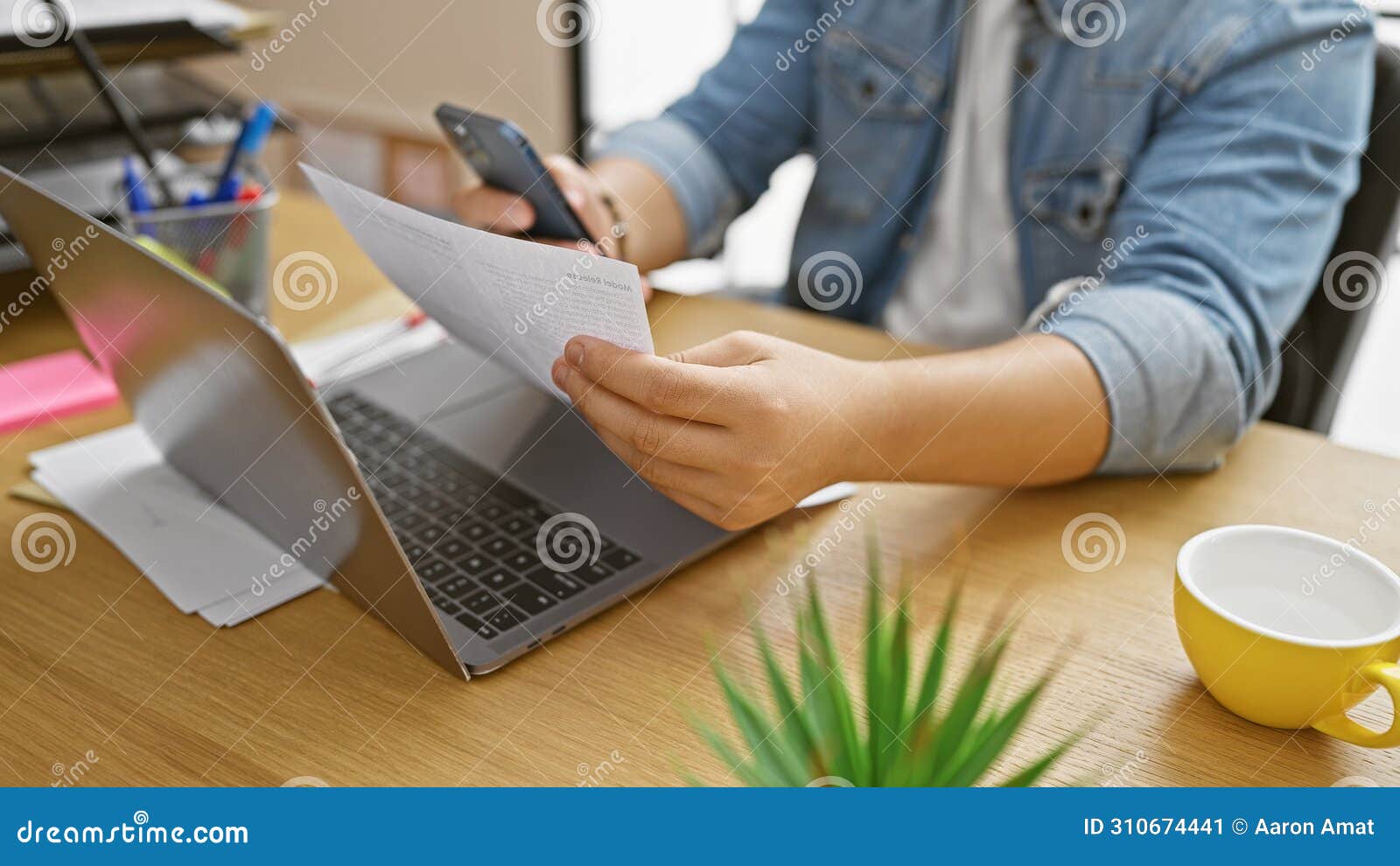 Professional Man Reviewing Document in Modern Office, Using Smartphone ...