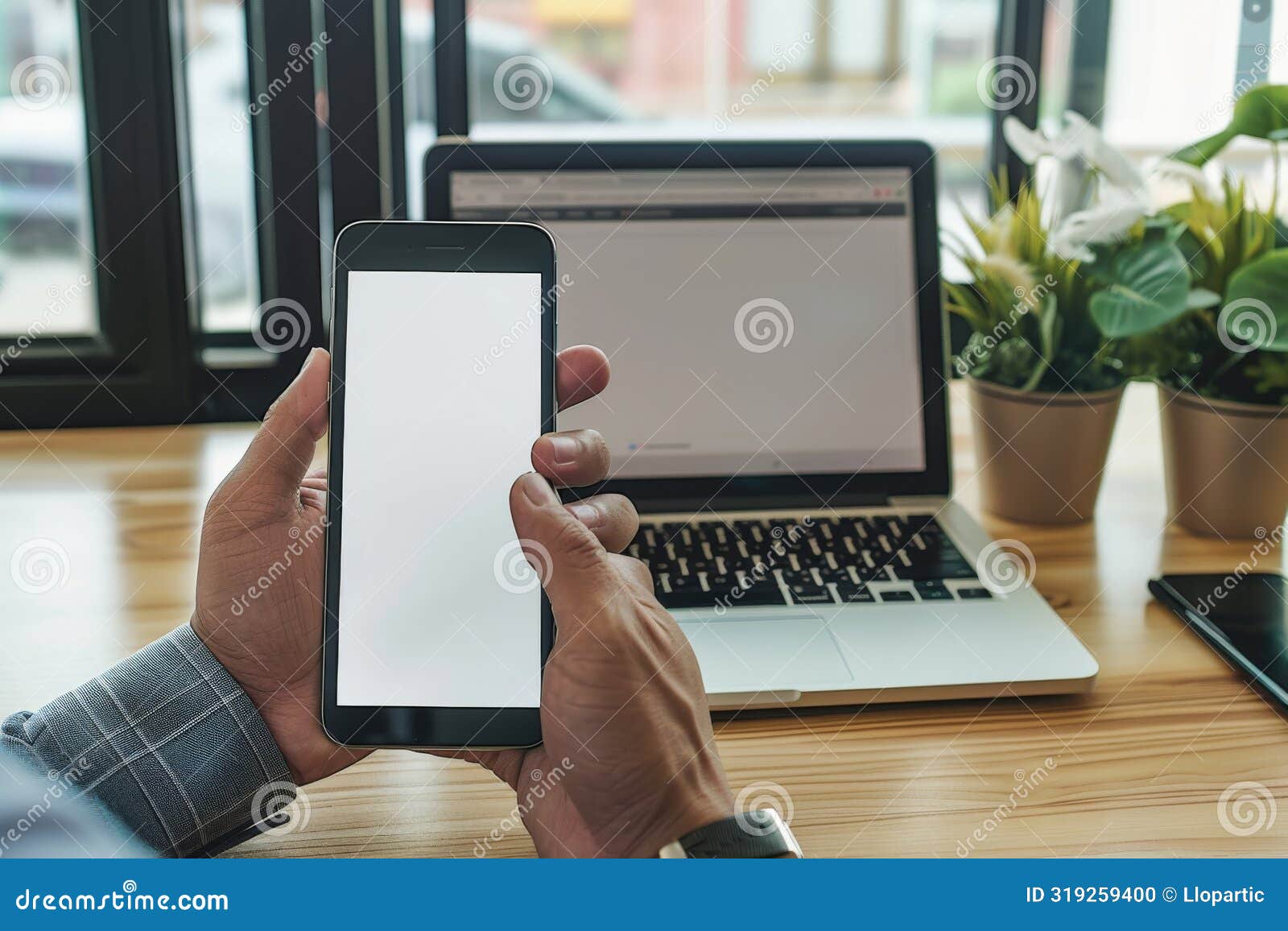 Professional Multitasking with a Smartphone and Laptop in a Modern ...