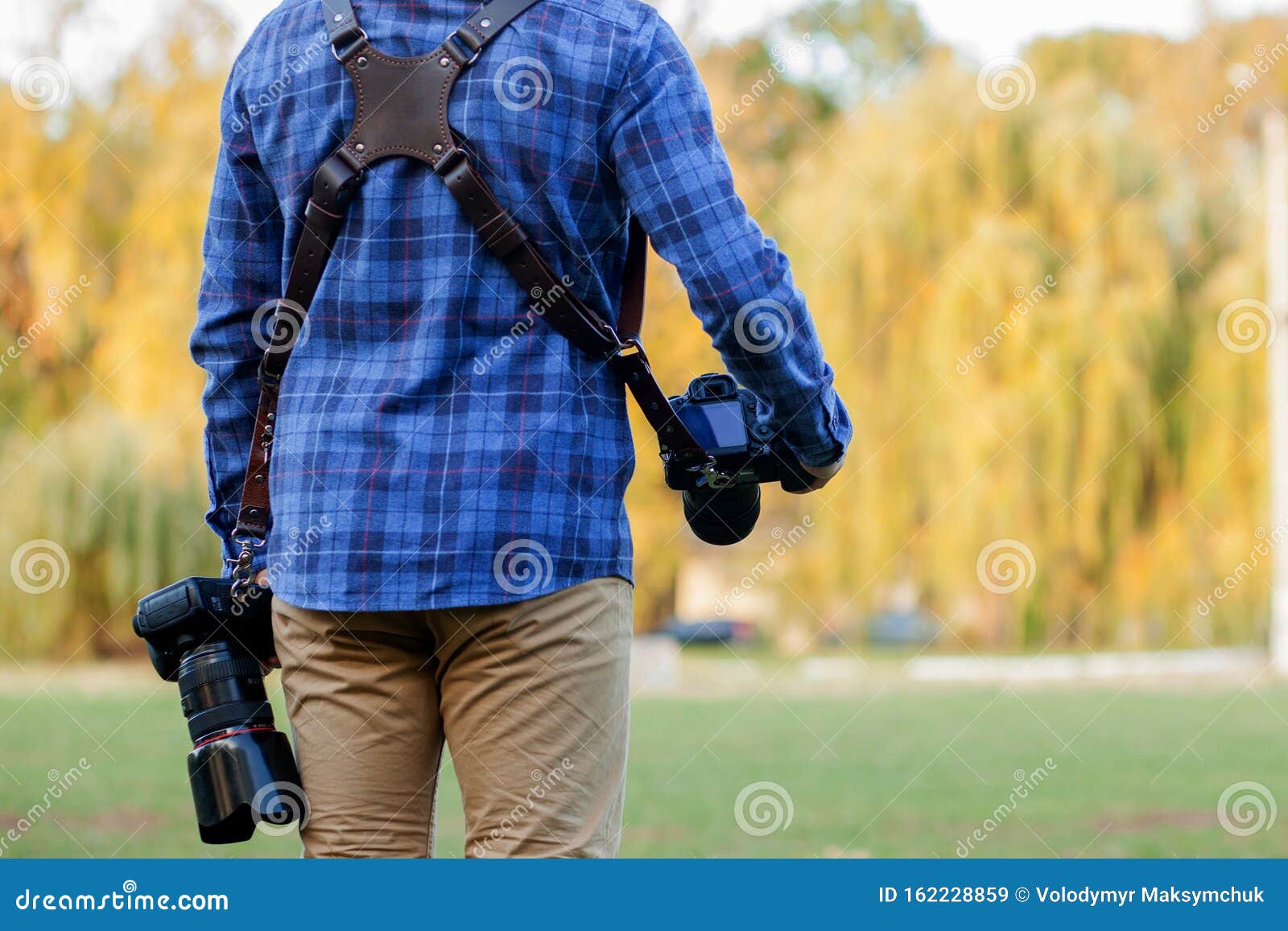 Professional Photographer in Action with Two Cameras on a Shoulder ...