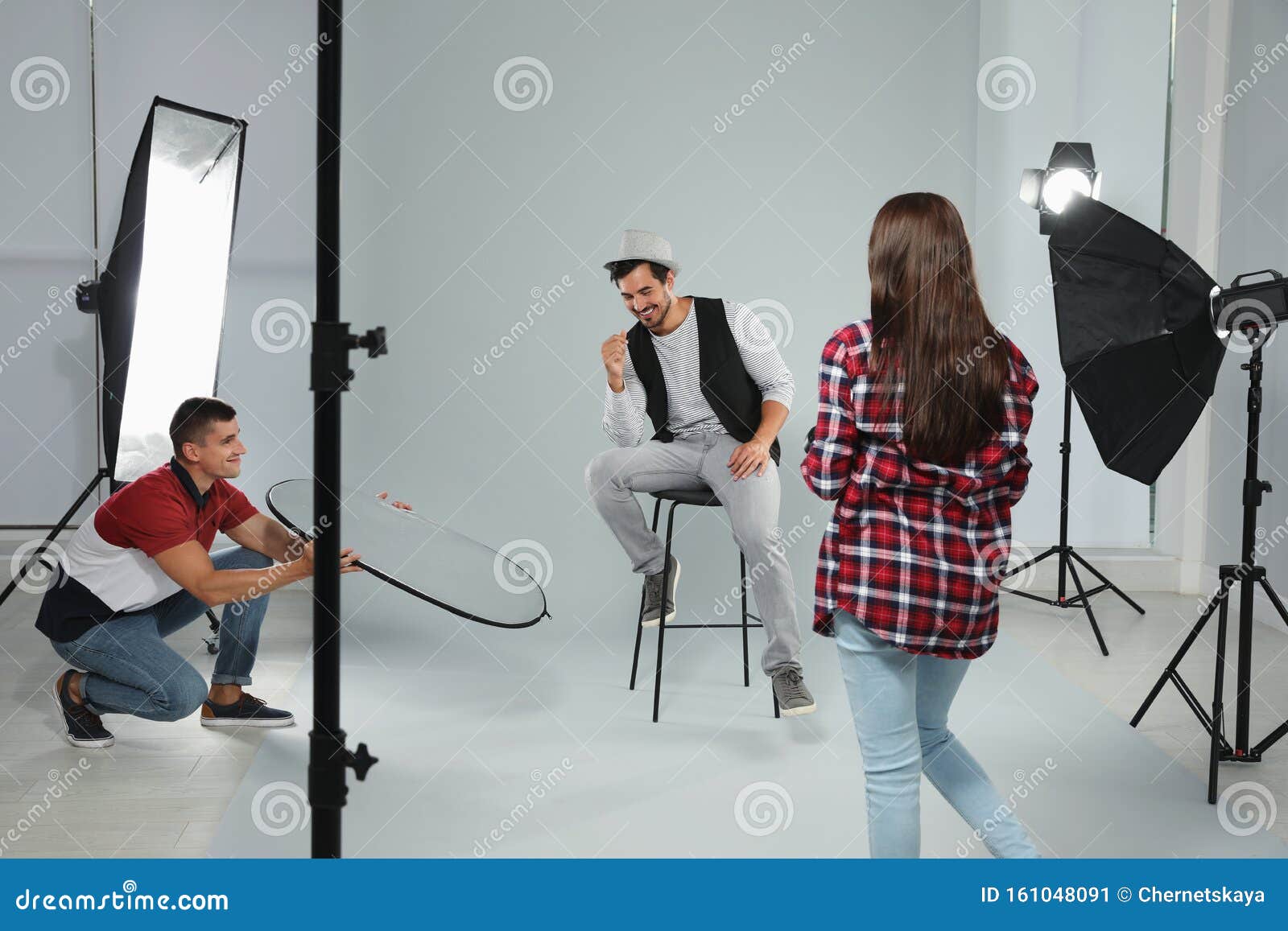 Professional Photographer with Assistant Taking Picture of Young Man in ...