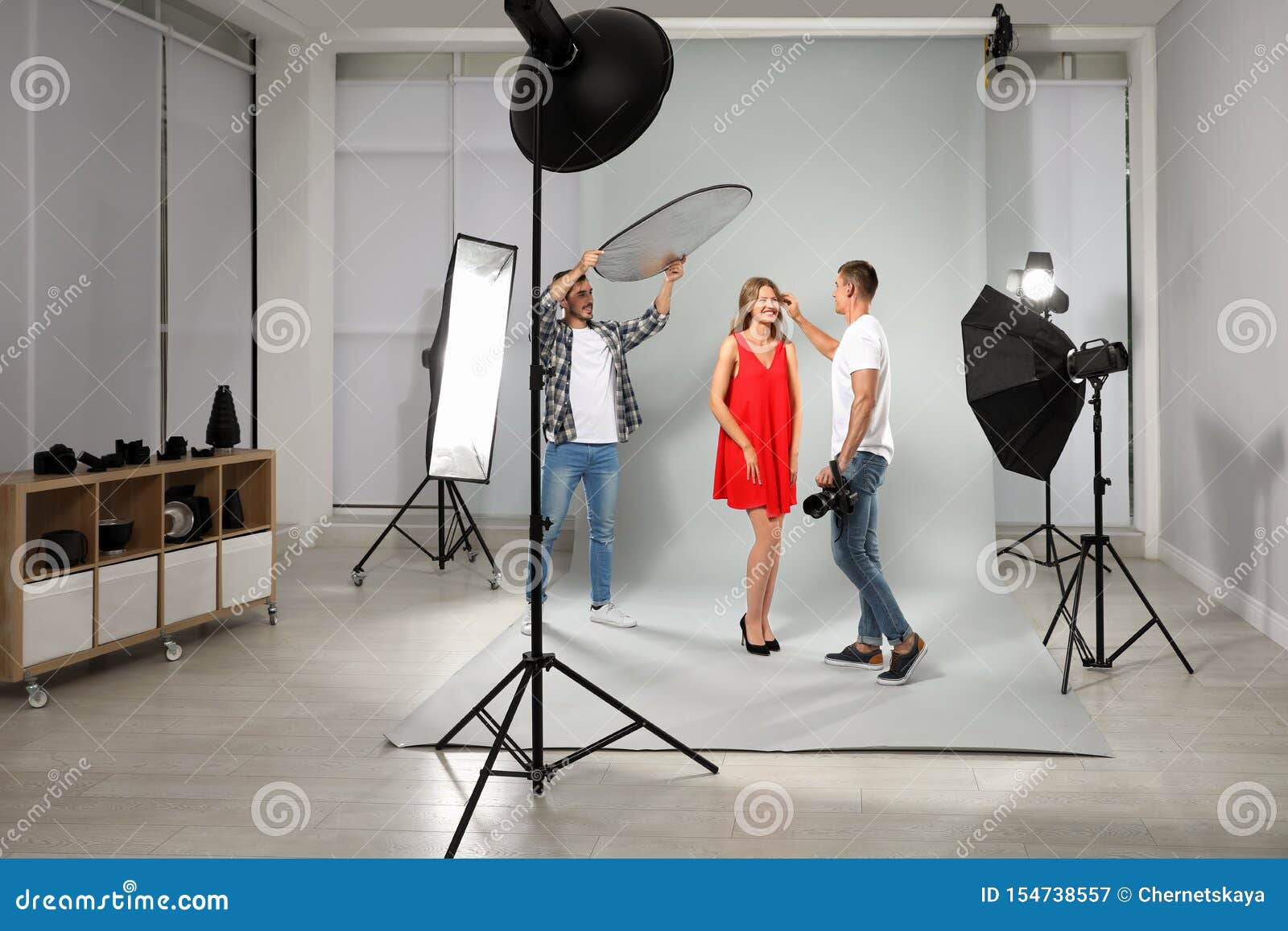Professional Photographer and Assistant Working with Model in Modern ...