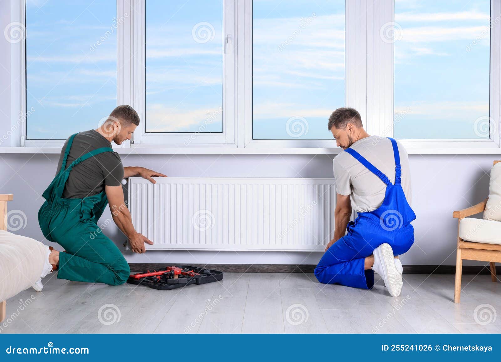 Professional Plumbers Installing New Heating Radiator in Room Stock ...