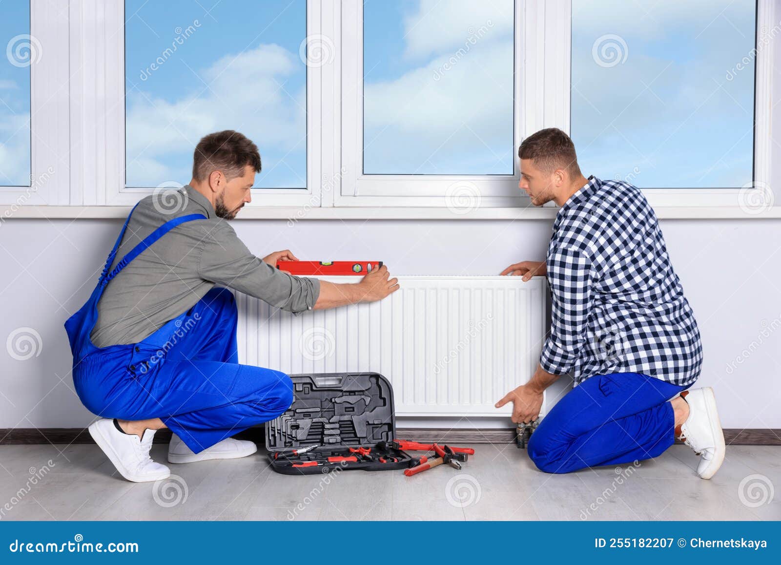 Professional Plumbers Using Bubble Level for Installing New Heating ...