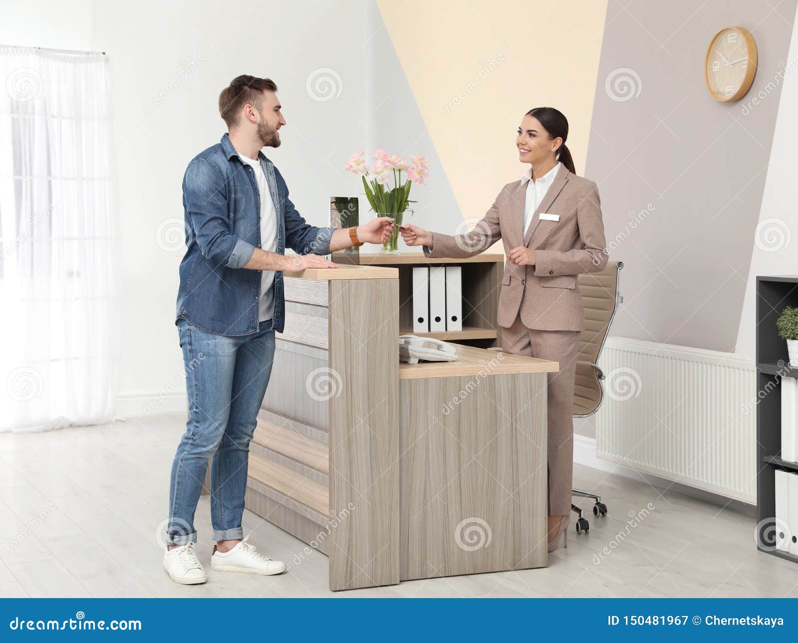 Professional Receptionist Working with Client at Desk in Hotel Stock ...