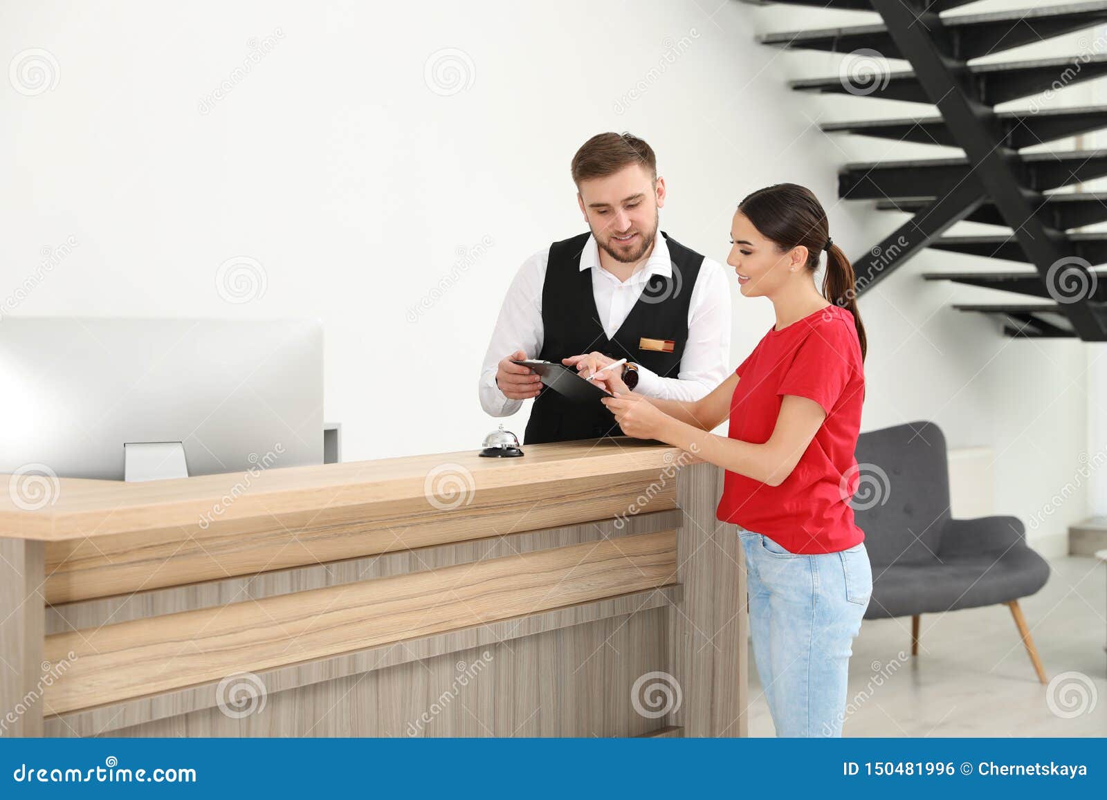 Professional Receptionist Working with Client at Desk Stock Photo ...