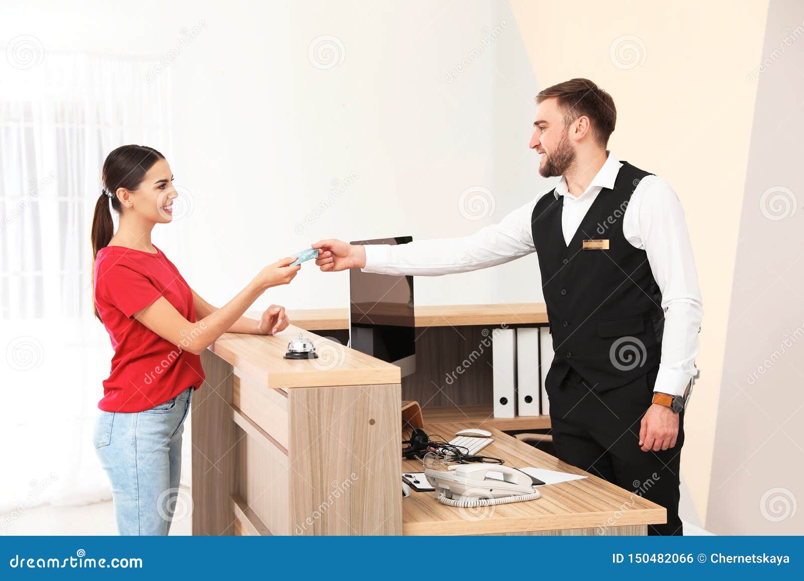 Professional Receptionist Working with Client at Desk in Hotel Stock ...