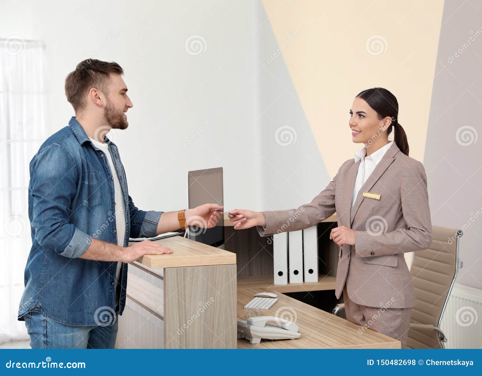 Professional Receptionist Working with Client at Desk Stock Photo ...
