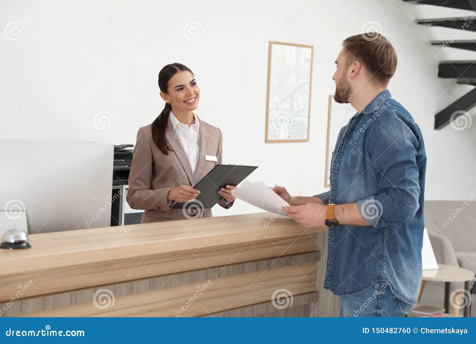 Professional Receptionist Working with Client at Desk Stock Photo ...