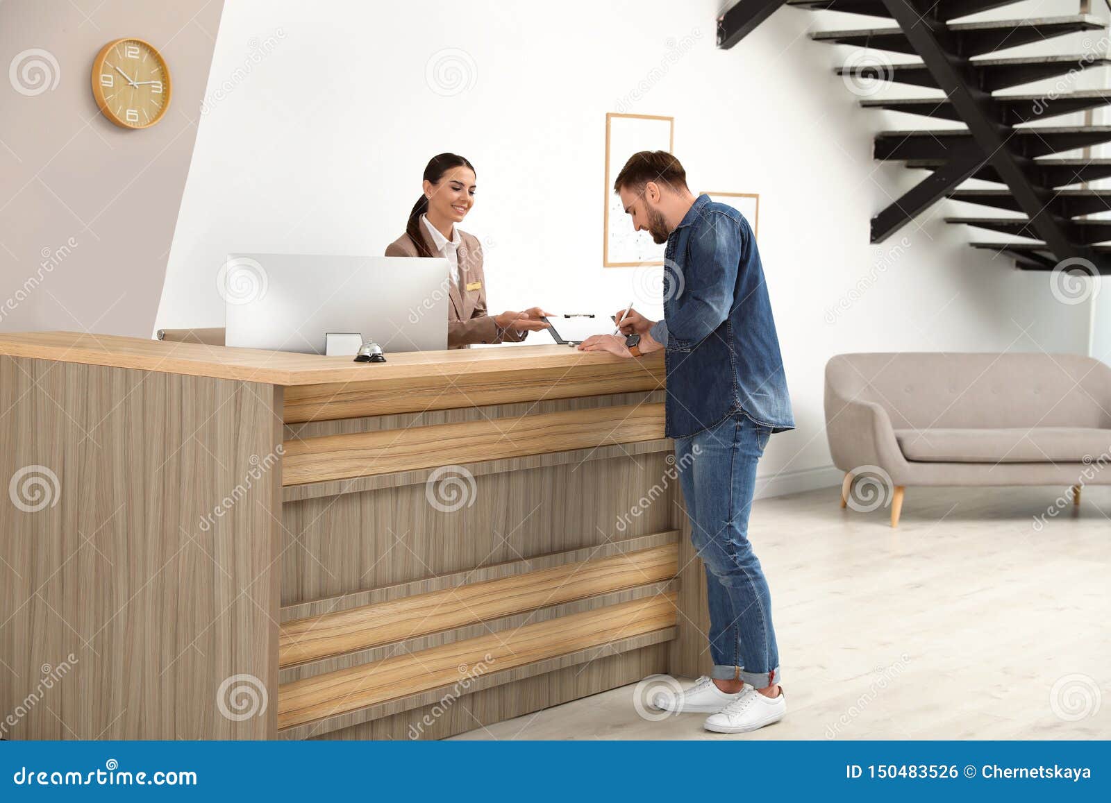 Professional Receptionist Working with Client at Desk Stock Photo ...