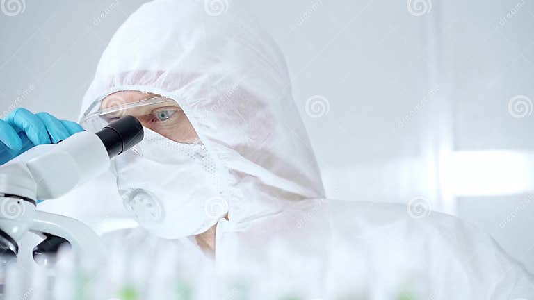 Professional Scientist in Protective Gear is Using Microscope in a ...