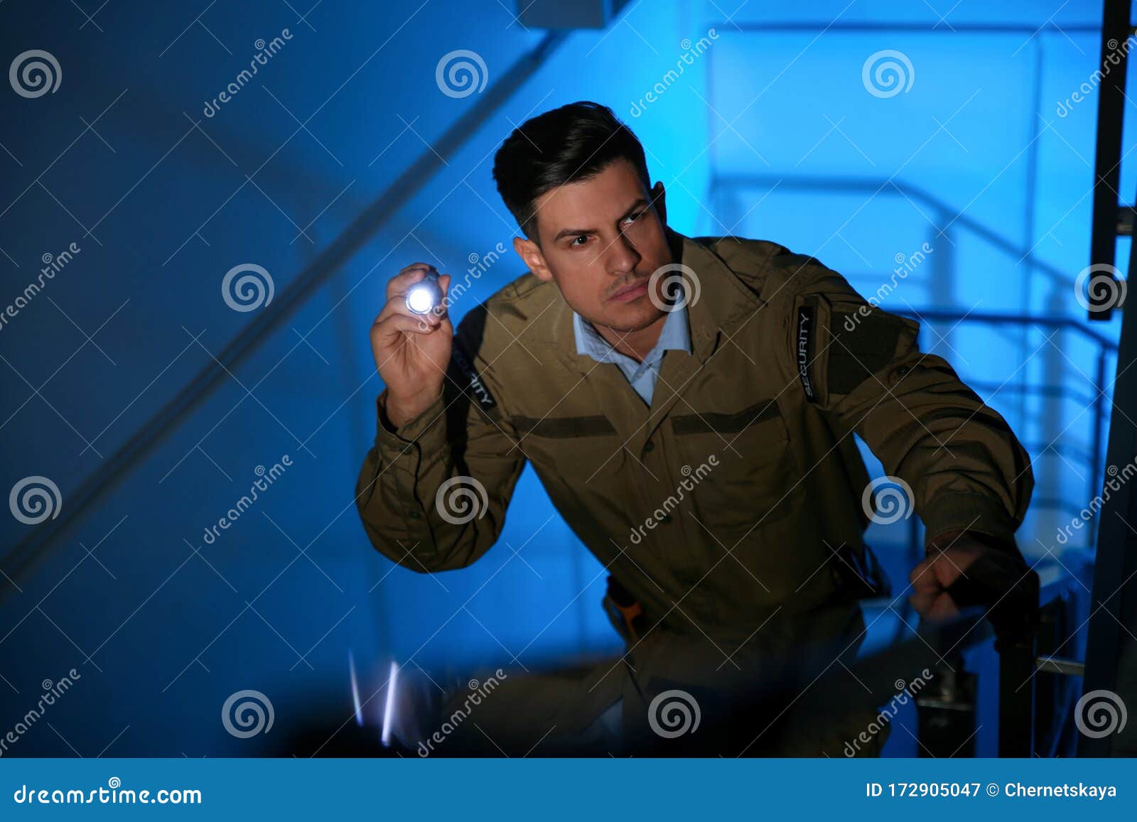 Professional Security Guard With Flashlight On Stairs In Room Royalty ...